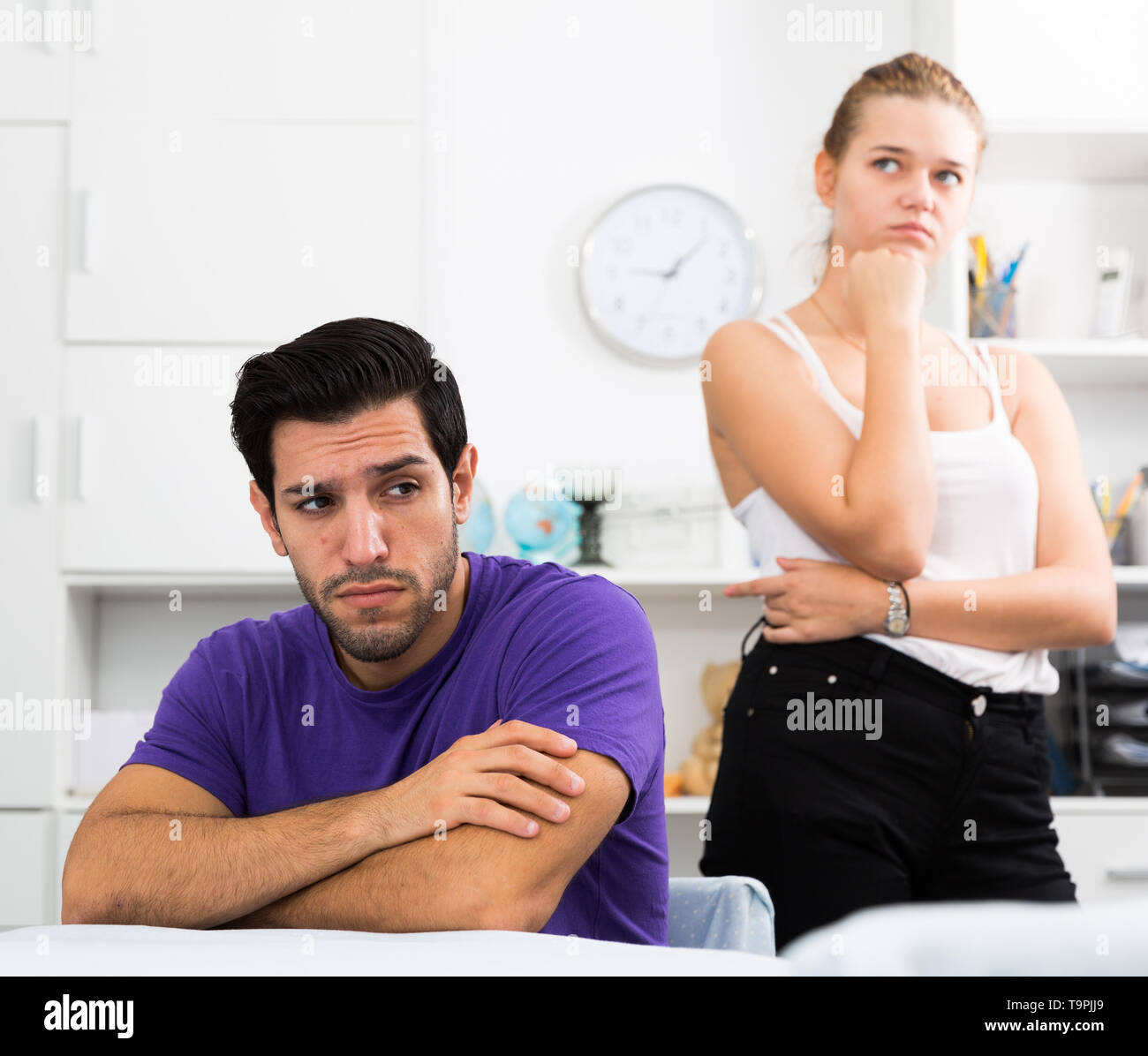 Young upset man sitting separately having problems in relationship with ...