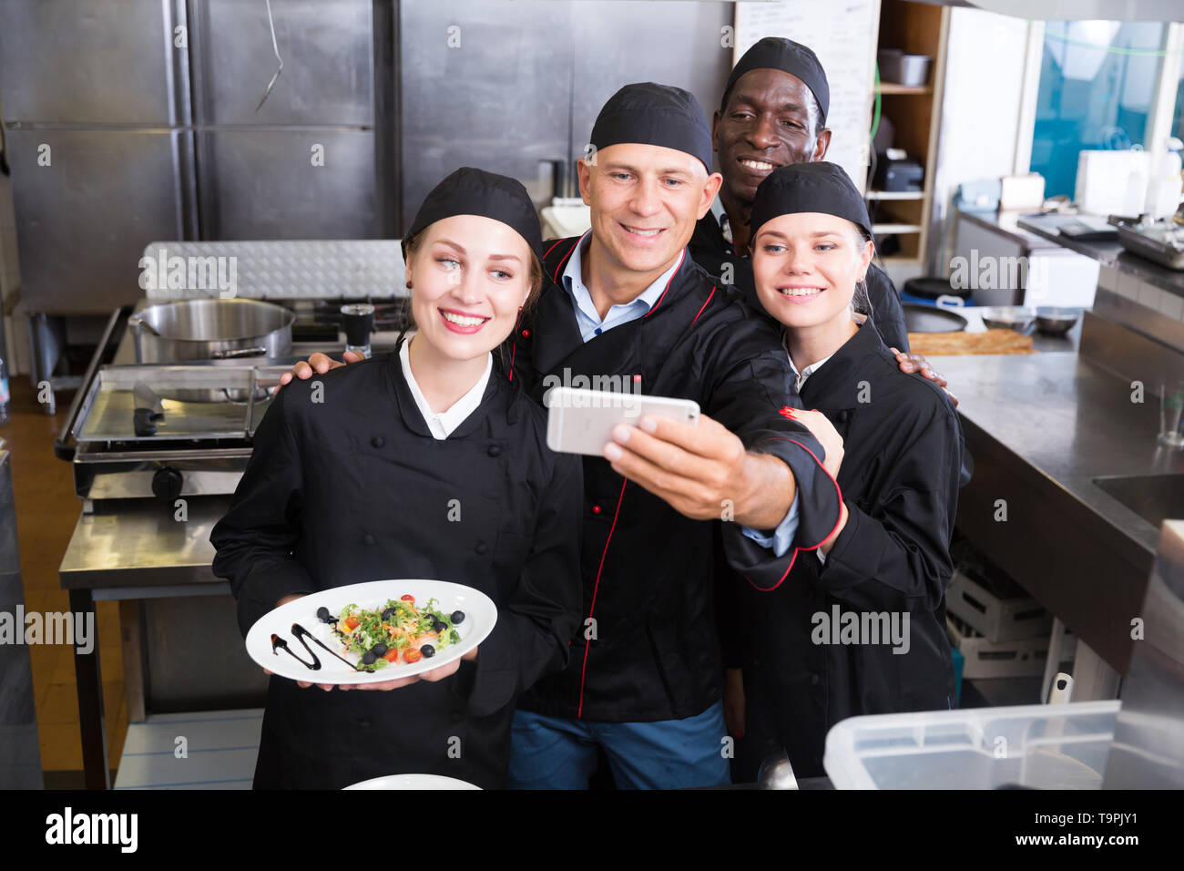 Smiling successful team of chefs making selfie in interior of ...