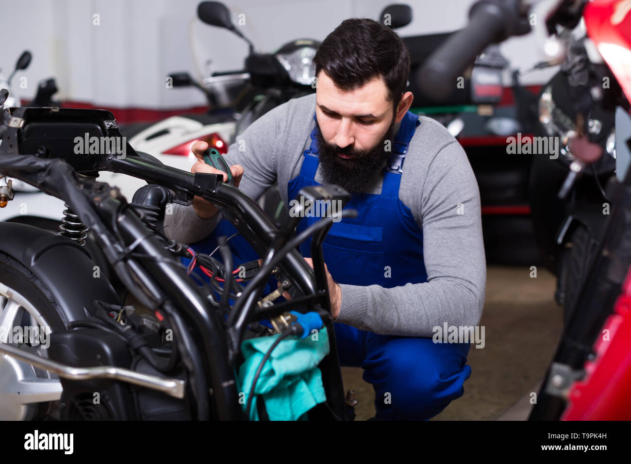 diligent man worker working at restoring motorbike in motorcycle ...