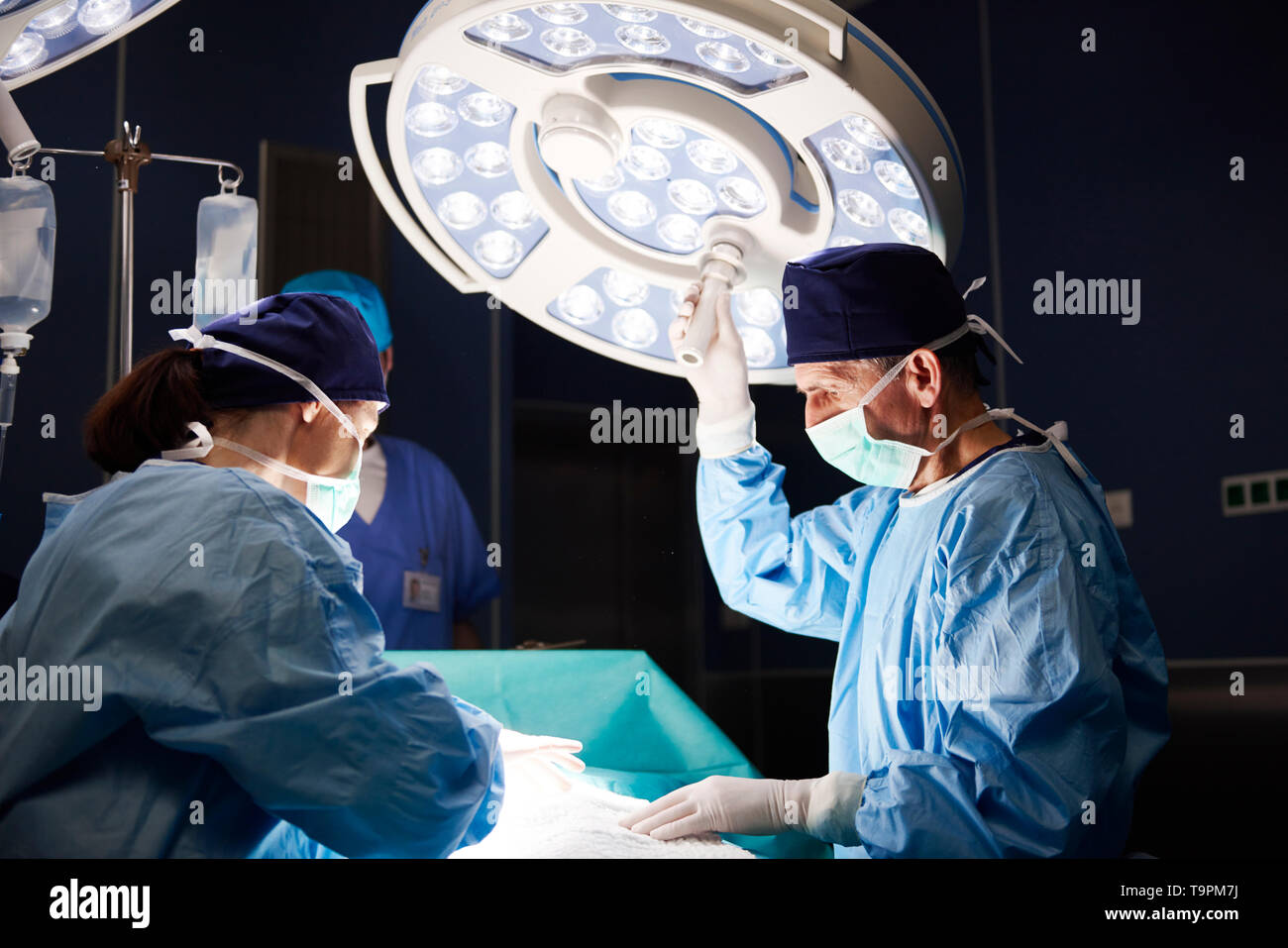 Mature surgeon setting the surgical light during an operation Stock ...