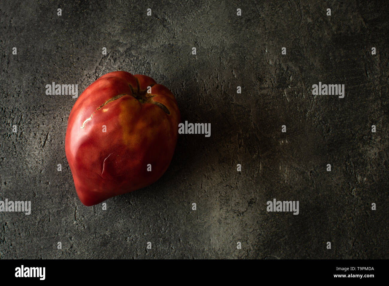 Organic Heirloom Tomato on Rustic Dark Background. Red Bull's Heart ...