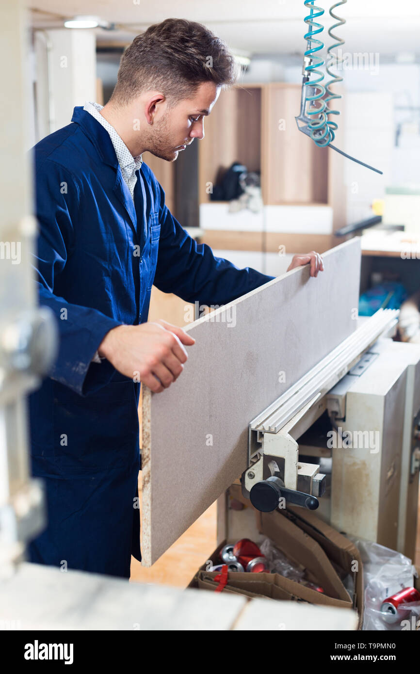 Young working man practising his skills with milling cutter at workshop ...