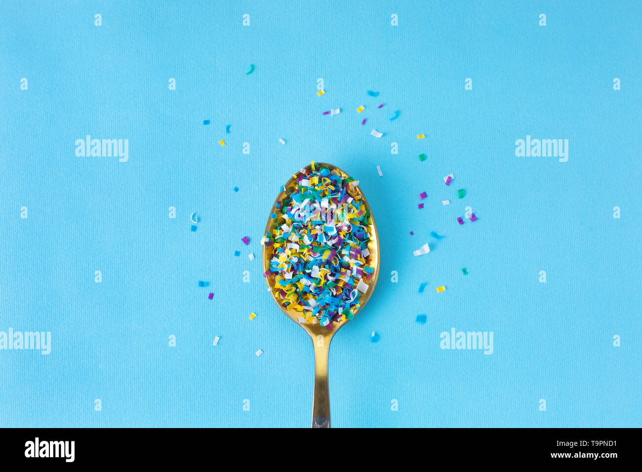 Microplastic in a spoon on blue background. microplastic in water and ...