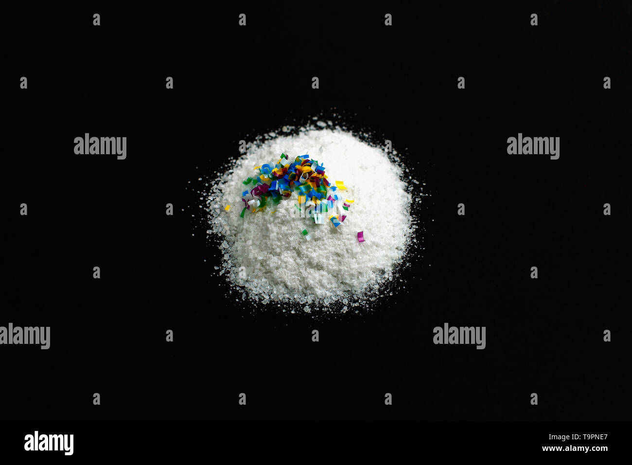 Microplastic particles in salt on black background. Water pollution ...