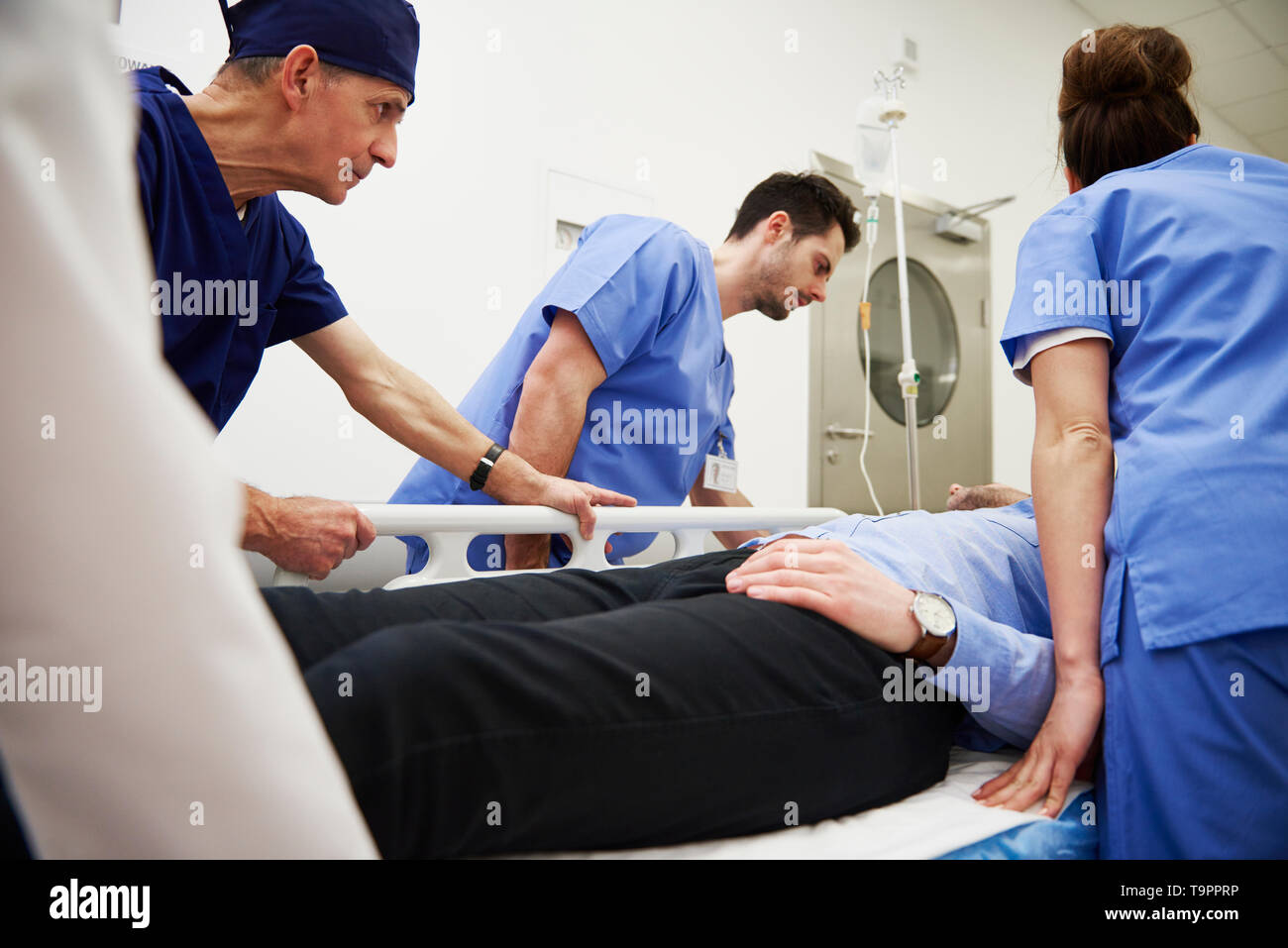 Side view of doctors running to the operating room Stock Photo - Alamy
