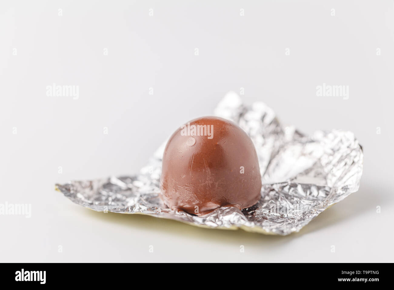 bitten chocolate candy in a candy wrapper Stock Photo - Alamy