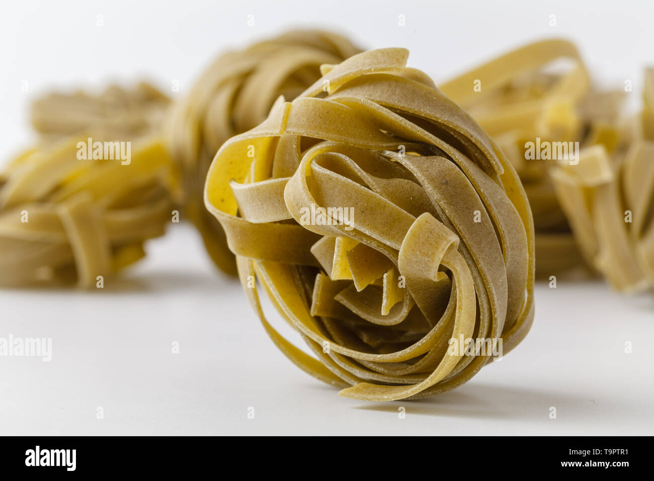 italian spinach tagliatelle nests on white Stock Photo - Alamy