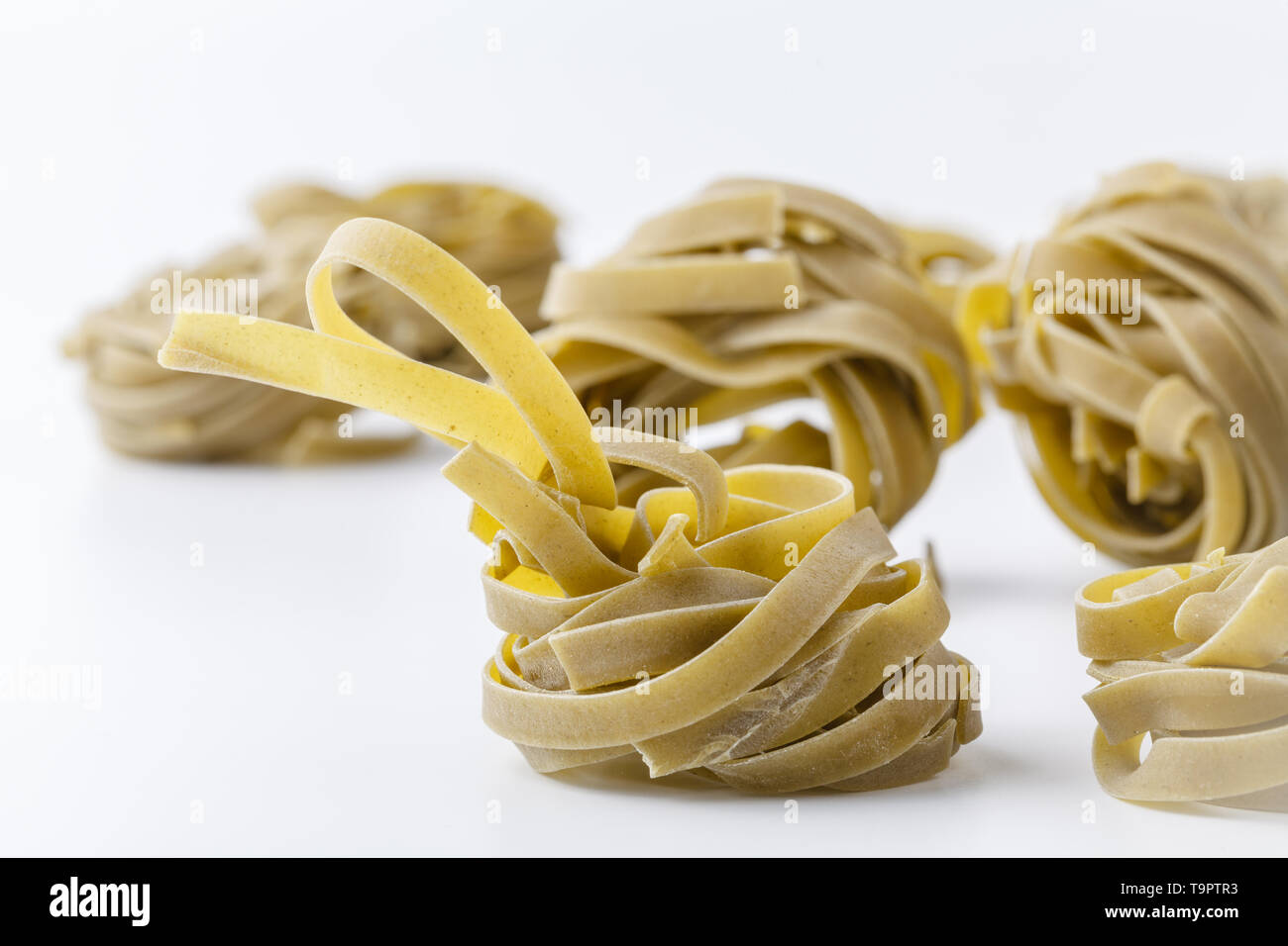 italian spinach tagliatelle nests on white Stock Photo - Alamy