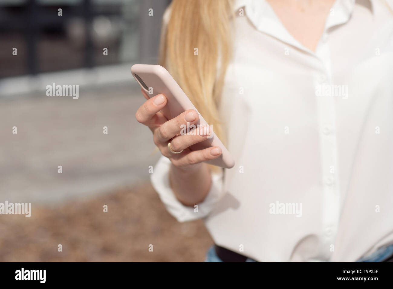 Close-up of women's hands holding cell telephone, young girl watching ...
