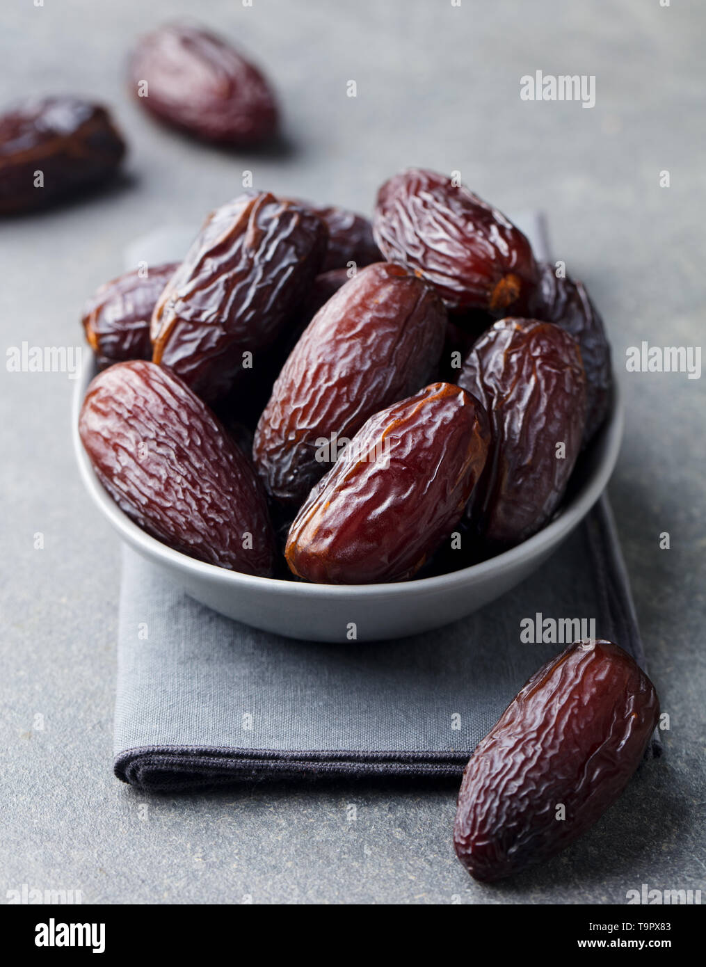 Fresh medjool dates in bowl. Grey background. Close up Stock Photo - Alamy