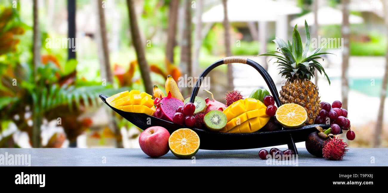 Tropical fruits assortment in wooden boat. Outdoor tropical background ...