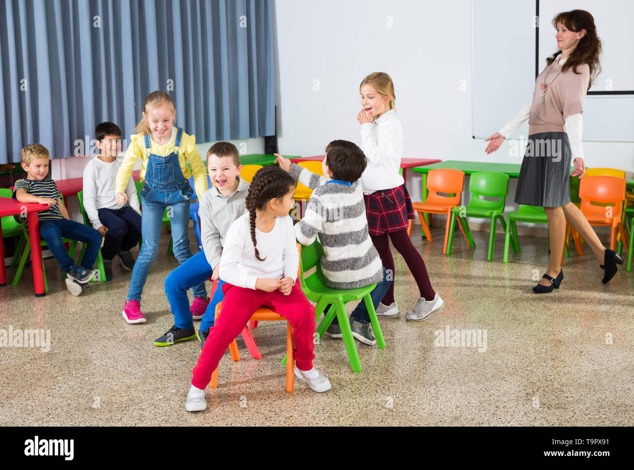 Happy laughing pupils of primary school having fun during break with ...