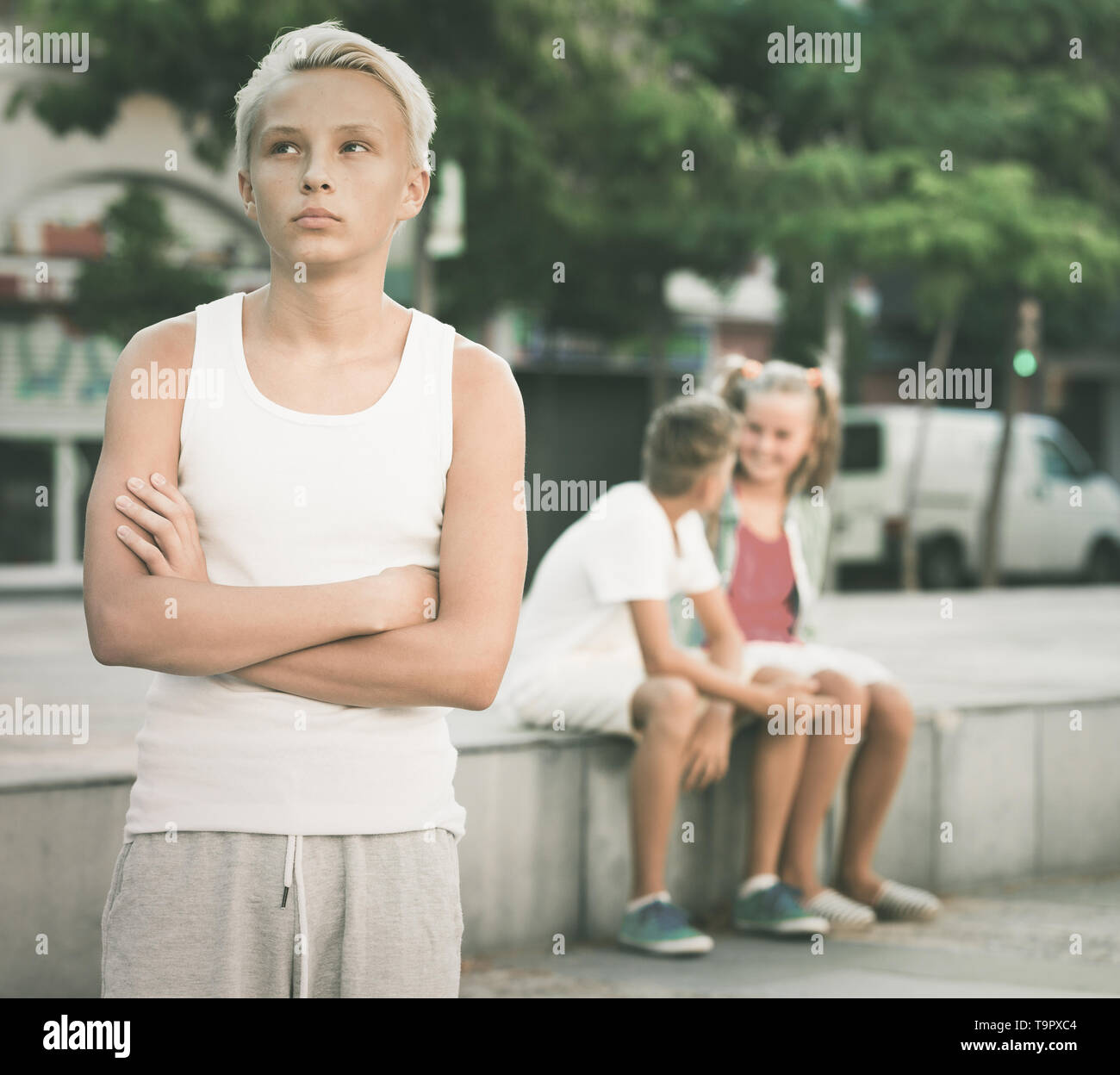 Portrait of offended boy not talking with friends after quarrel ...