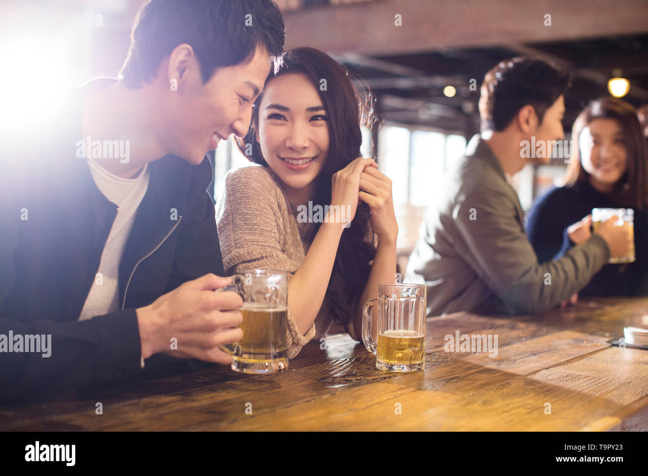 Young women drinking beer talking hi-res stock photography and images ...