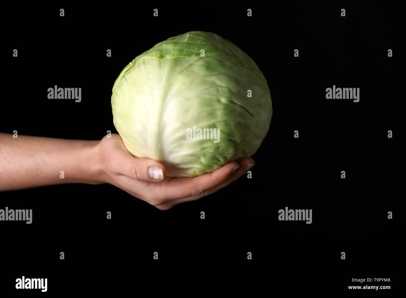 Female hand with fresh cabbage on dark background Stock Photo - Alamy