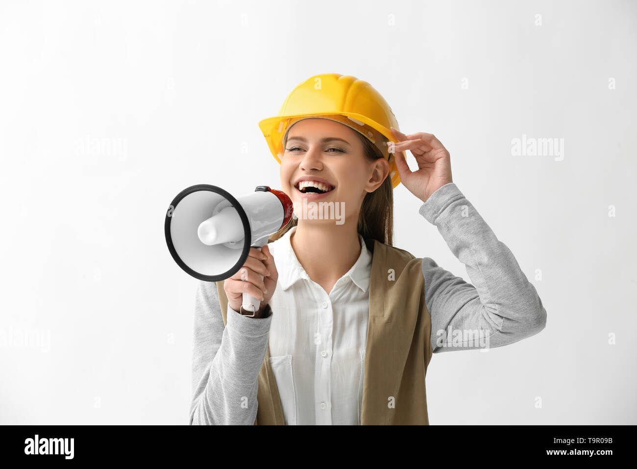Female engineer with megaphone on white background Stock Photo - Alamy