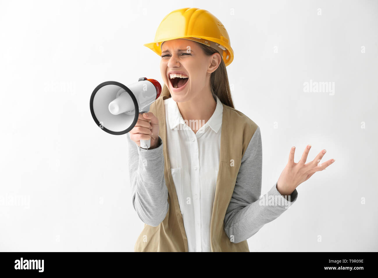 Female engineer with megaphone on white background Stock Photo - Alamy