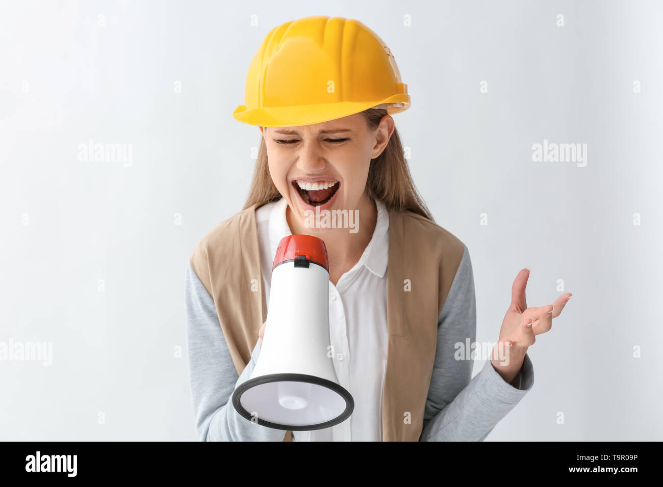 Female engineer with megaphone on white background Stock Photo - Alamy
