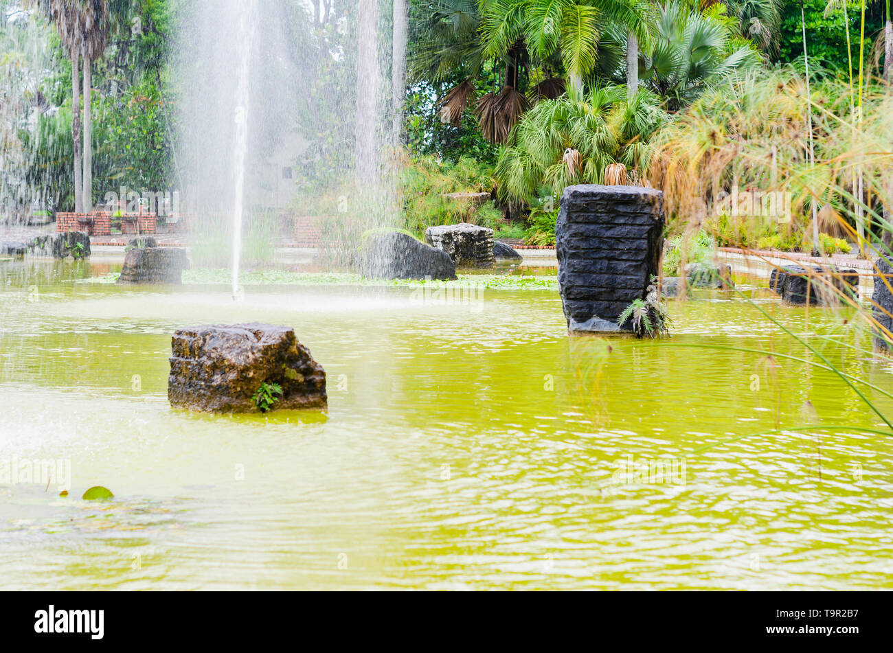 pond with granite rocks adorning a fountain in the foreground and ...
