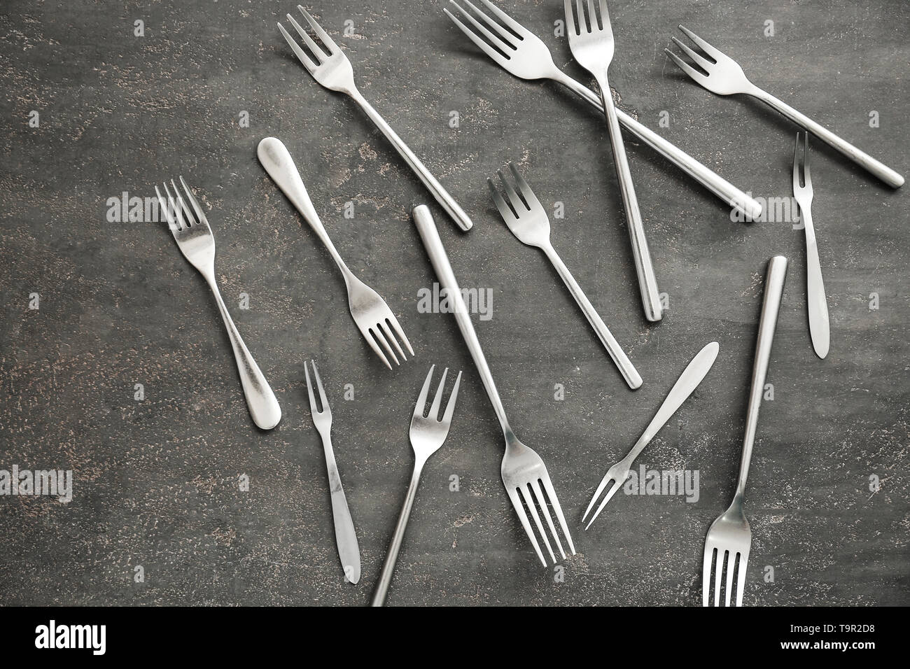 Set of forks on grey background Stock Photo - Alamy