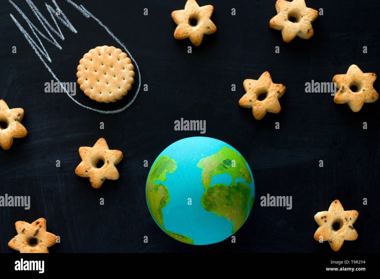 top view handmade model of Earth planet, cookie meteorite and cookies ...