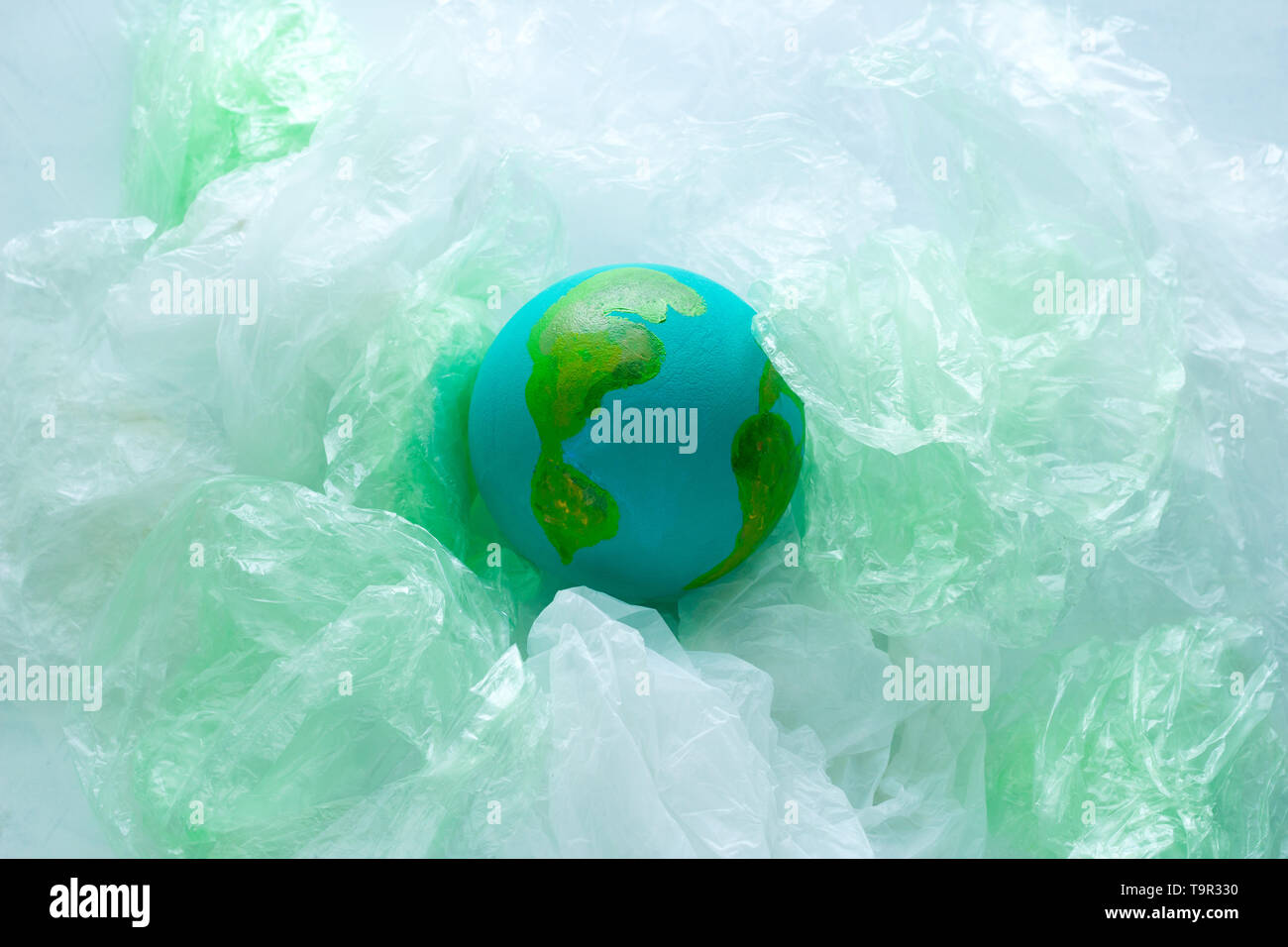 top view of a small model of the Earth planet among plastic bags ...