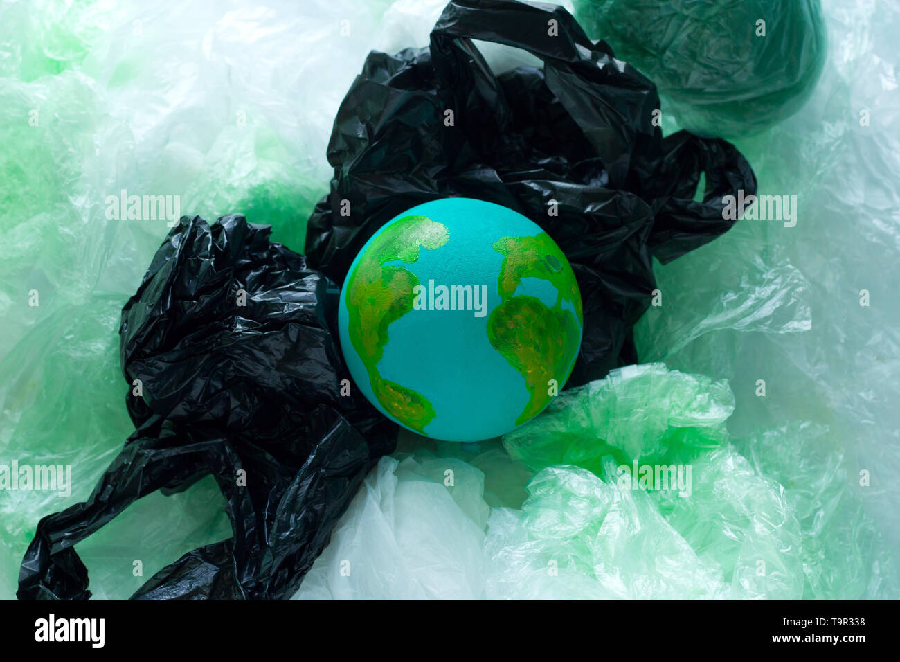 top view of a small model of the Earth planet among plastic bags ...