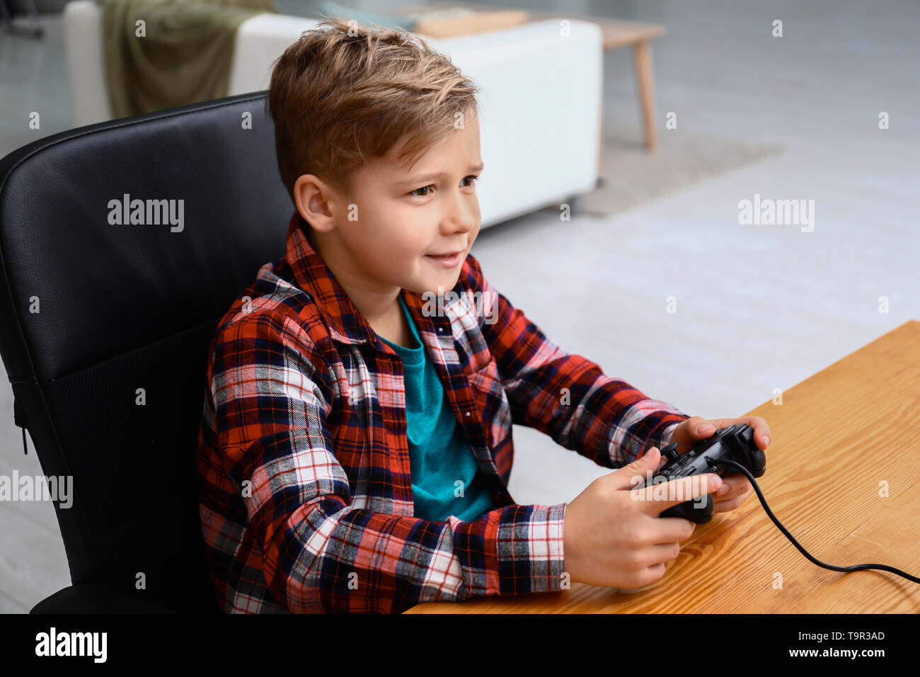 Cute boy playing video game at home Stock Photo - Alamy