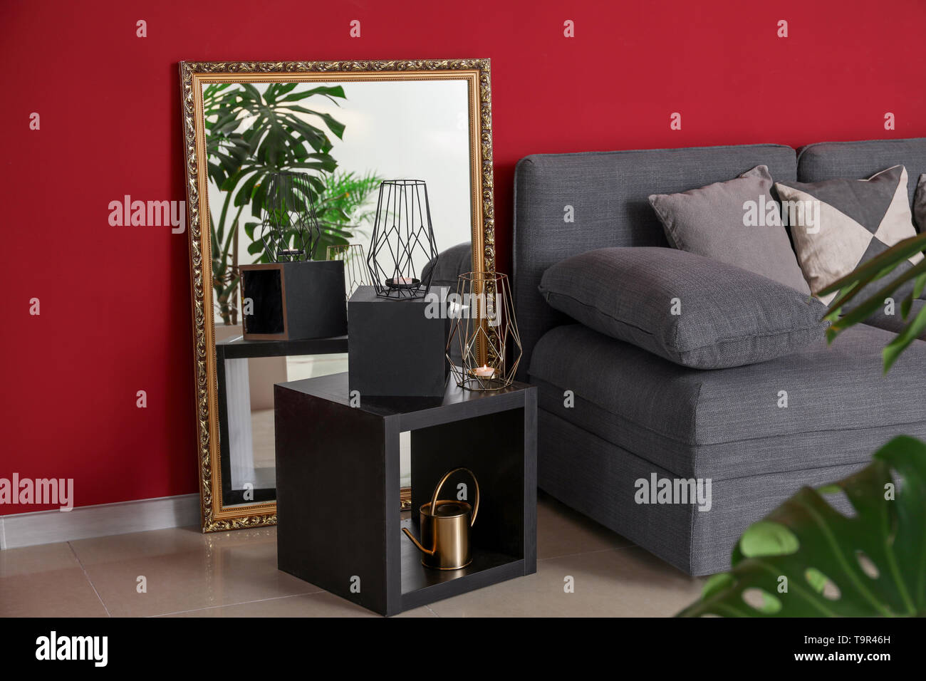 Interior of living room with comfortable grey sofa, mirror and golden ...