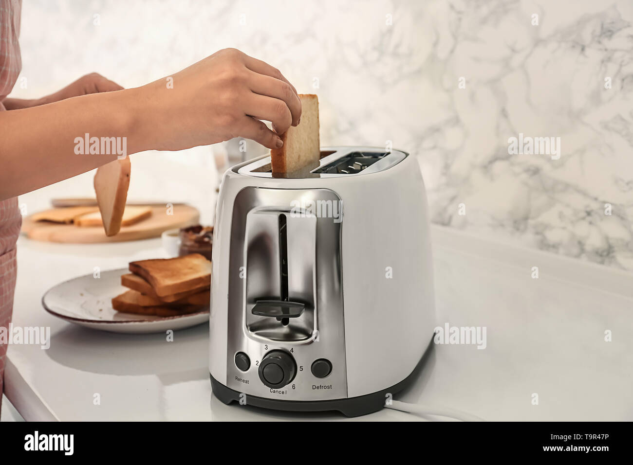 Woman preparing toasts for breakfast in kitchen Stock Photo - Alamy