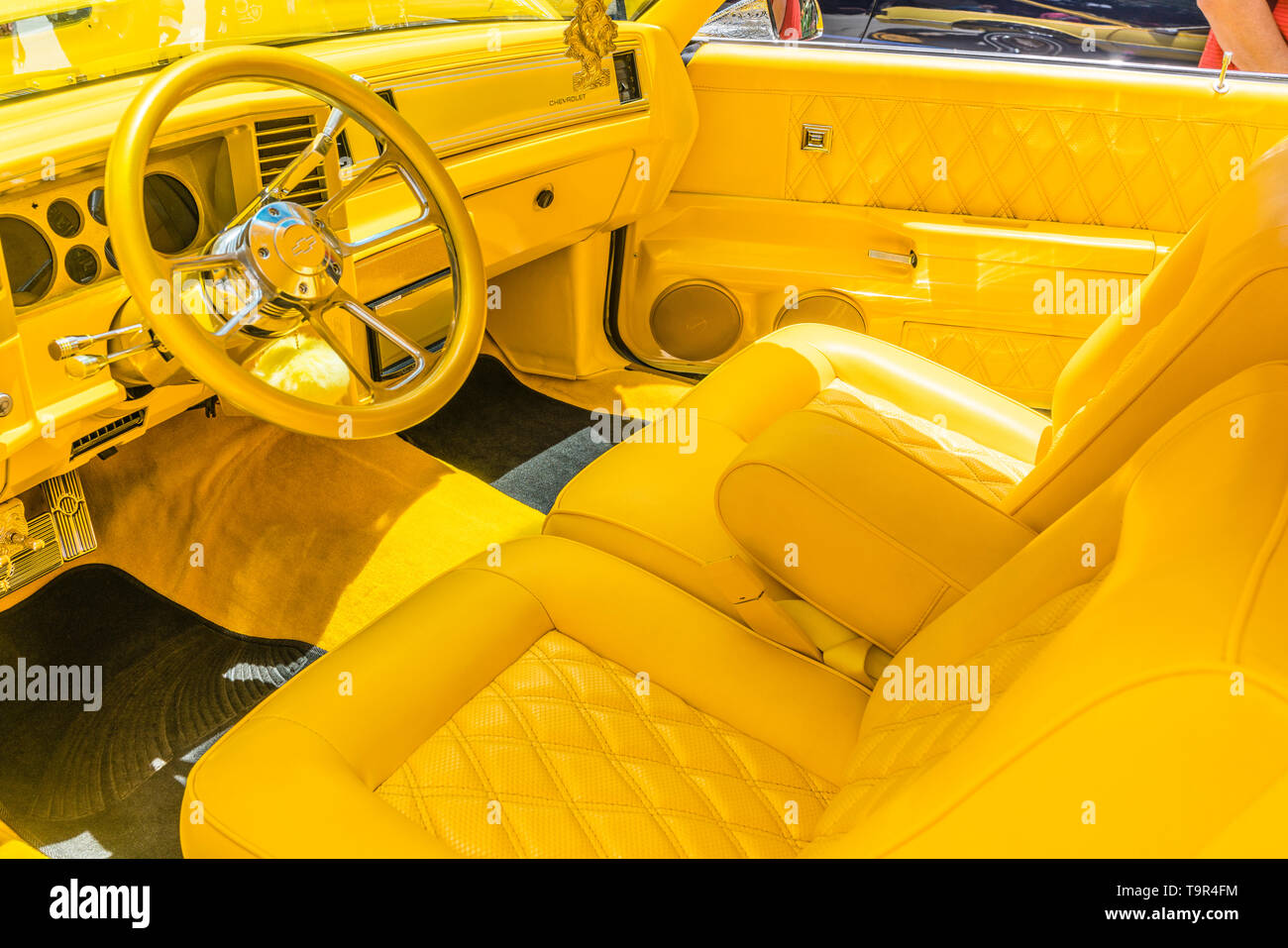 A detail of the interior of a bright yellow Chevrolet lowrider car that ...