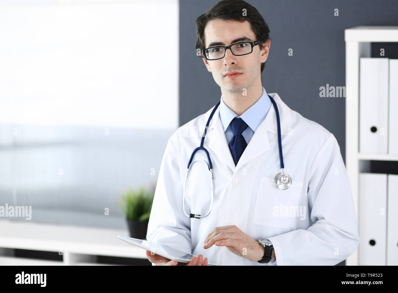 Doctor man using tablet computer for network research or virtual ...