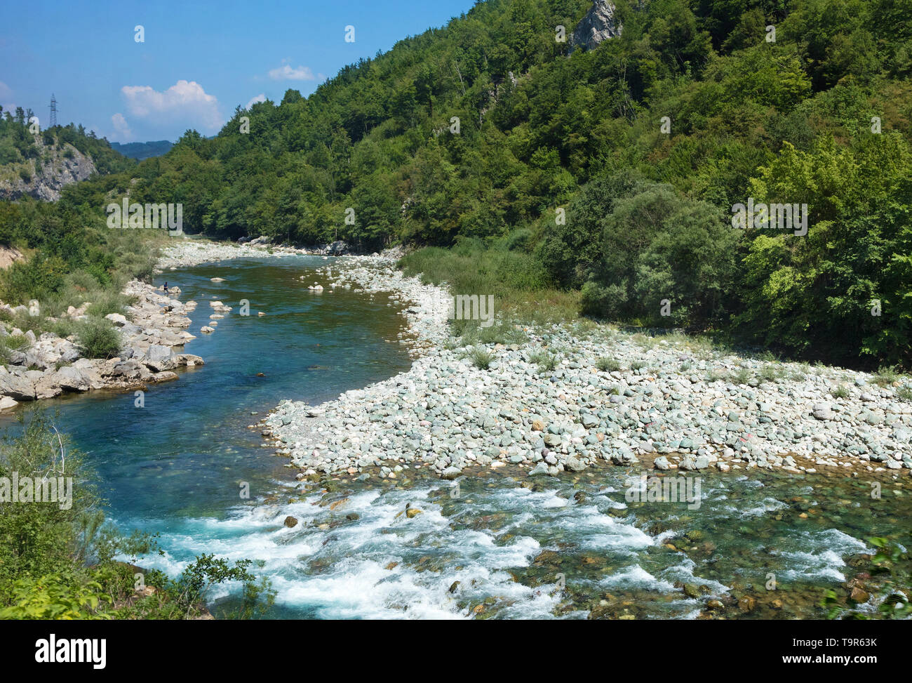 The pure turquoise water of the mountain river overcomes the stone ...