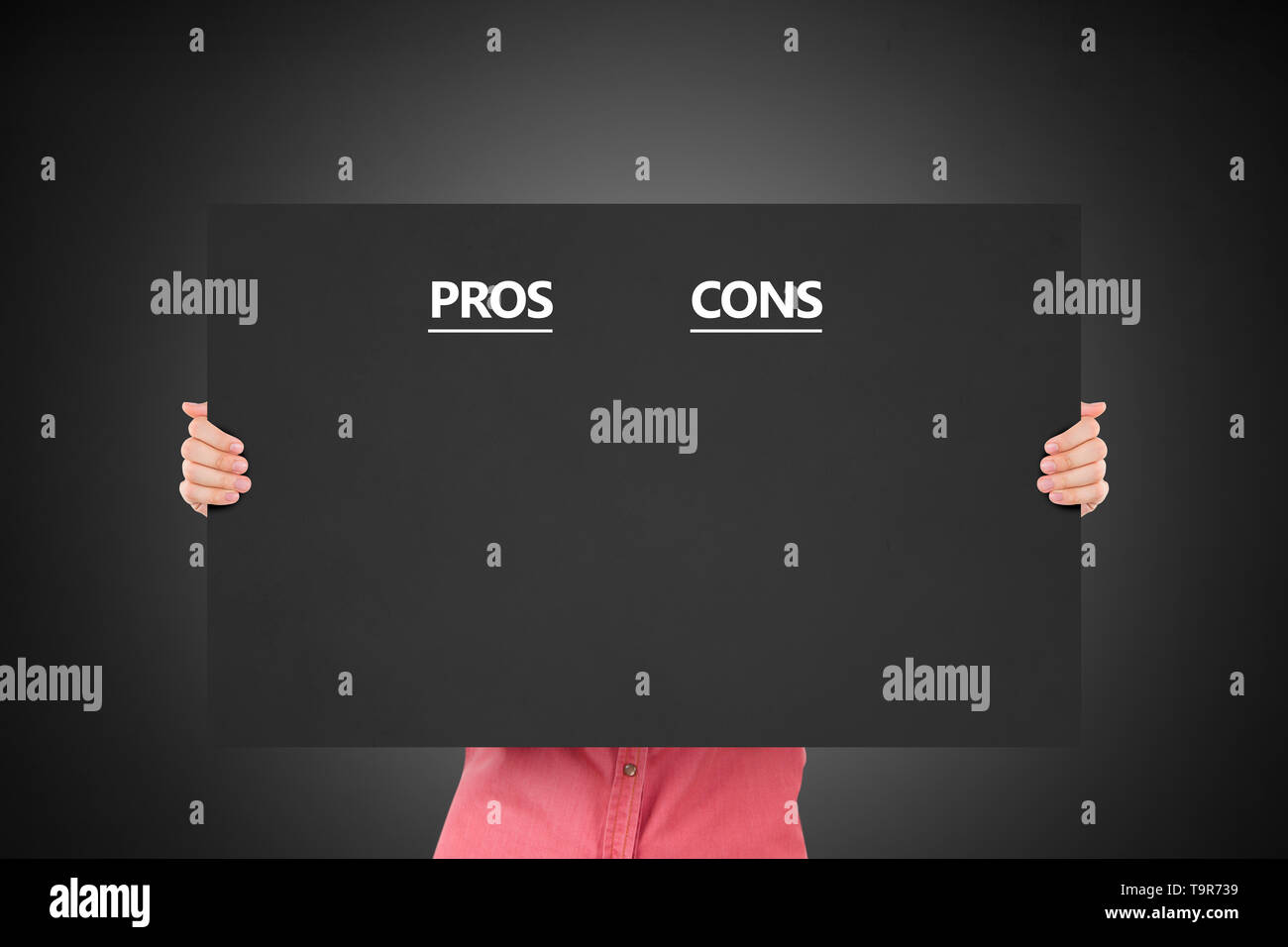 Hand holding pros and cons sign with copy space for your text on black ...