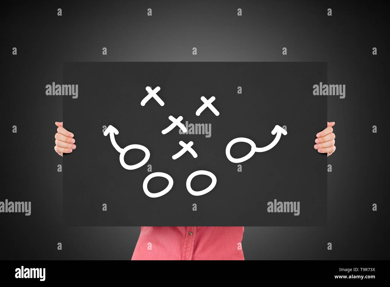 Hand holding tactical sign with arrows on black board Stock Photo - Alamy