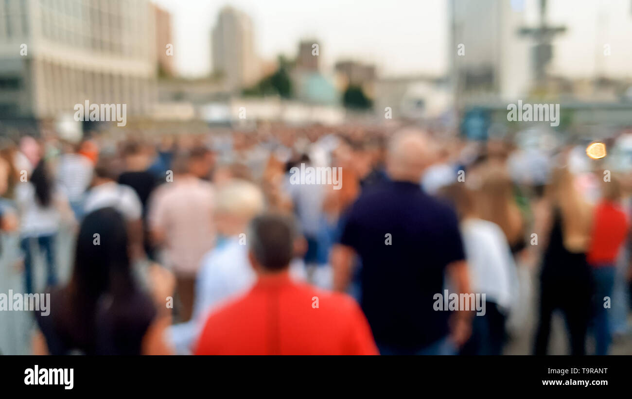 Out of focus image of big crowd of people walking on the city street ...