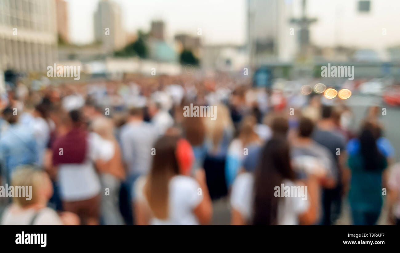 Out of focus image of big crowd of people walking on the city street ...