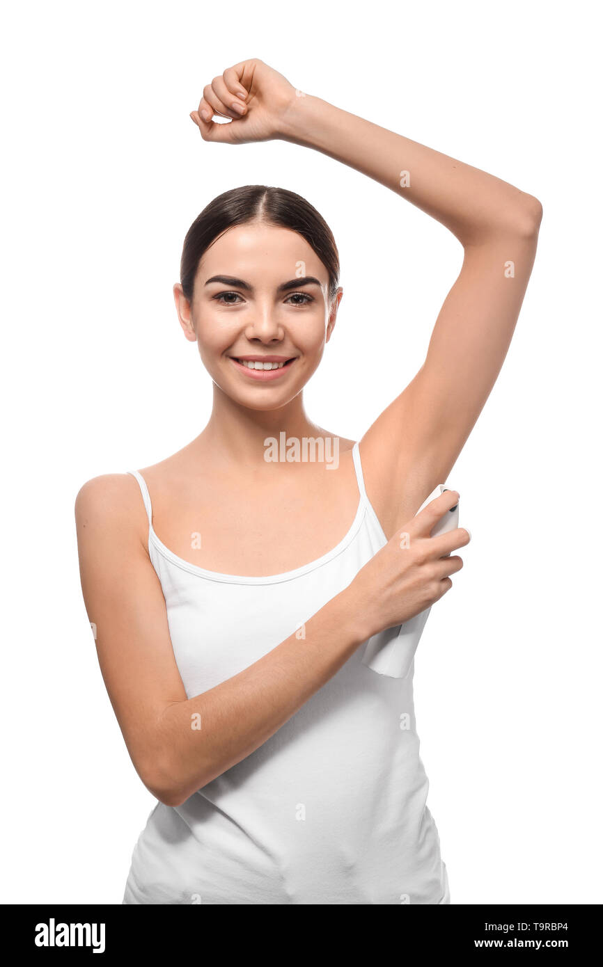 Young woman using deodorant on white background Stock Photo - Alamy