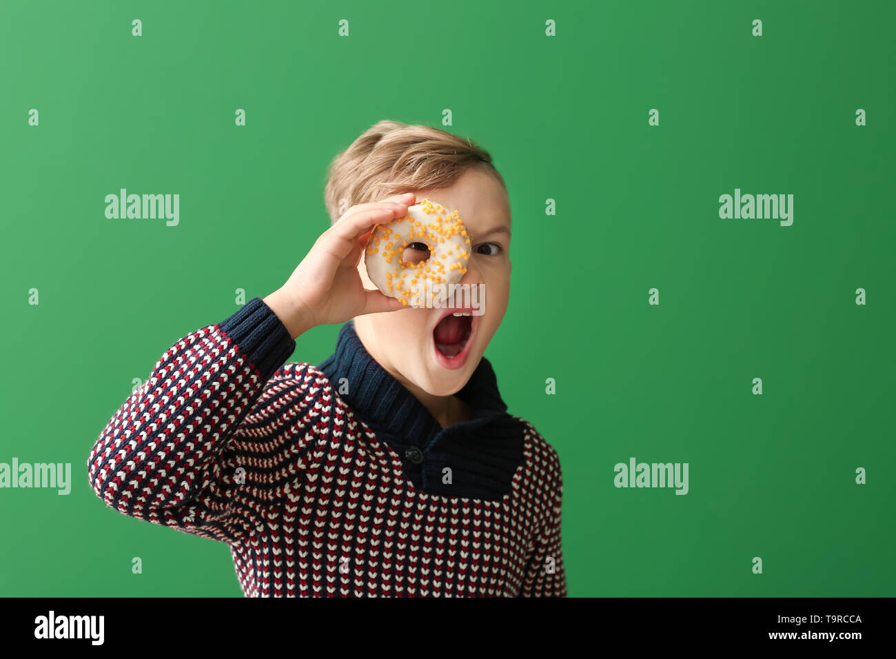 Screaming little boy with donut on color background Stock Photo - Alamy