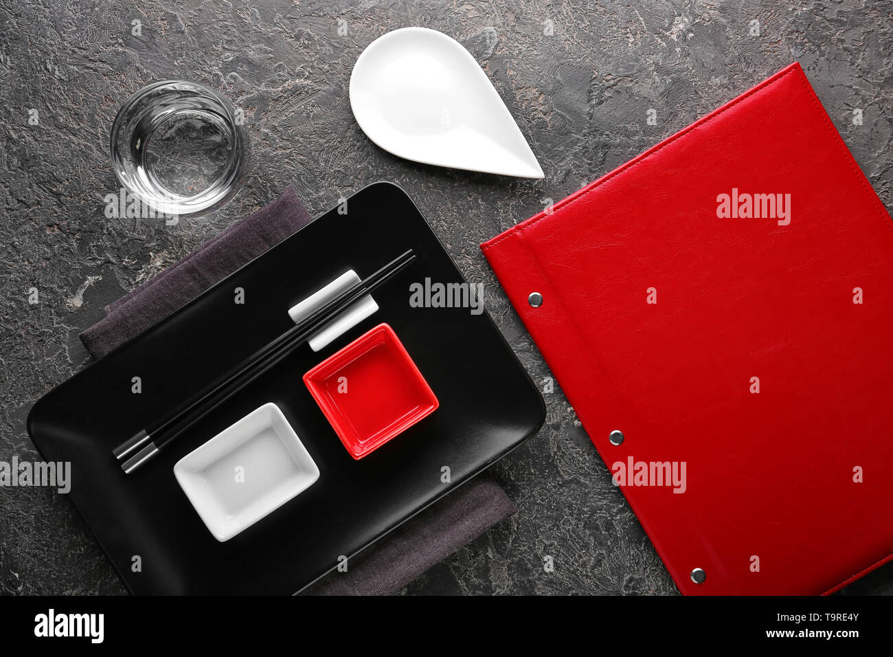 Table setting with menu on grey background Stock Photo - Alamy