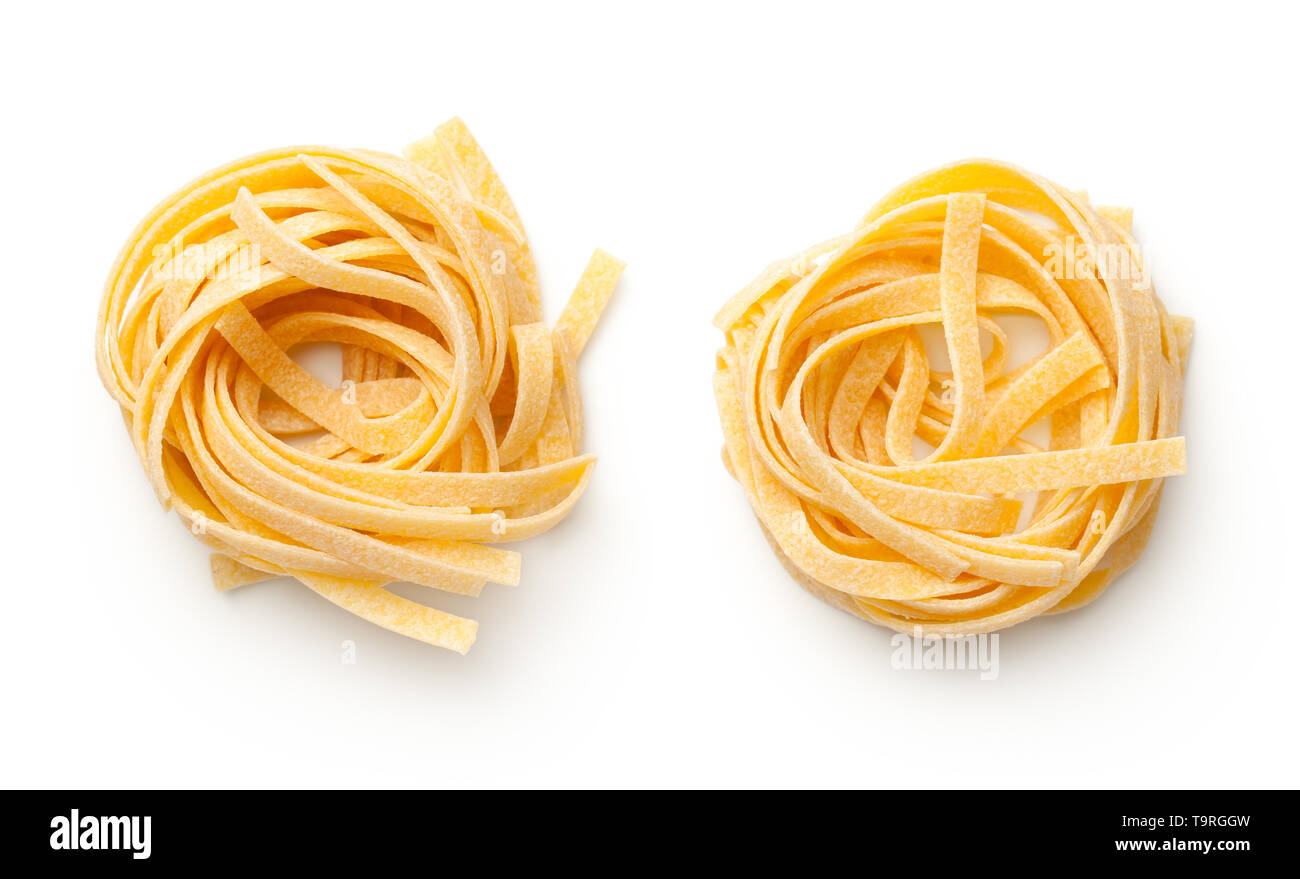 Raw tagliatelle pasta nests isolated on white background. Top view ...