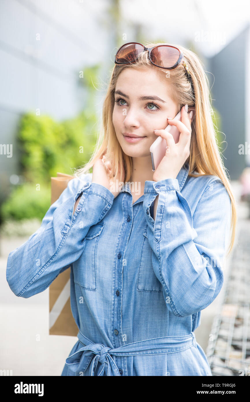 Beautiful young girl calling in shopping mall with baggs Stock Photo ...