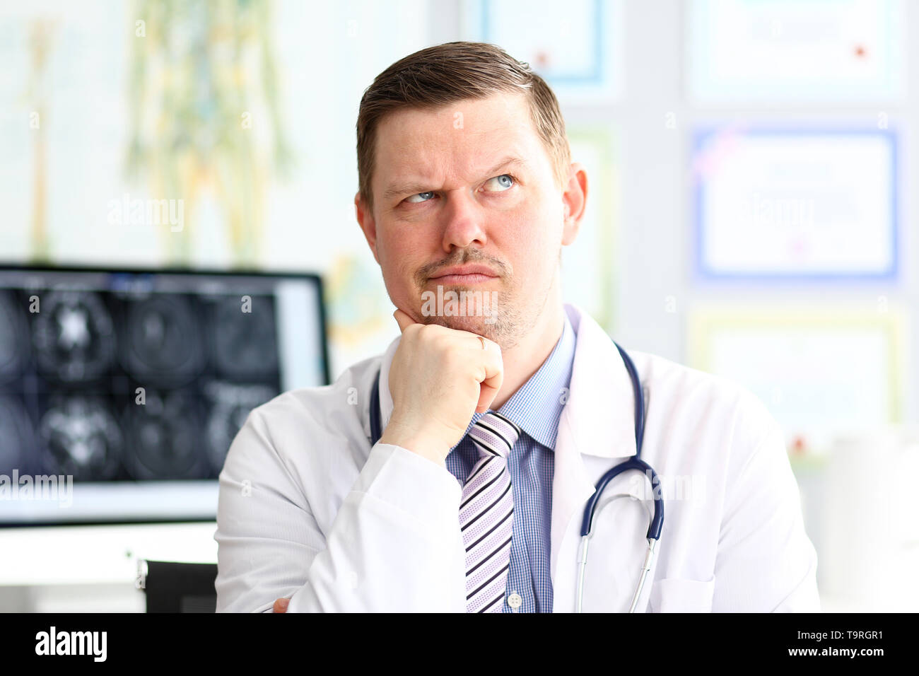 Male doctor with strange facial expression sit in his office Stock ...