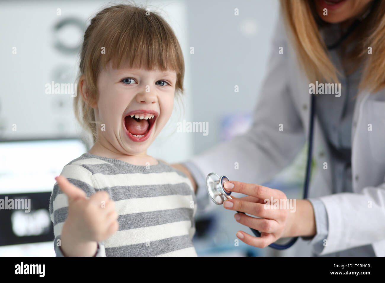 Cute little girl at doctor office showing respect gratitude and approve ...