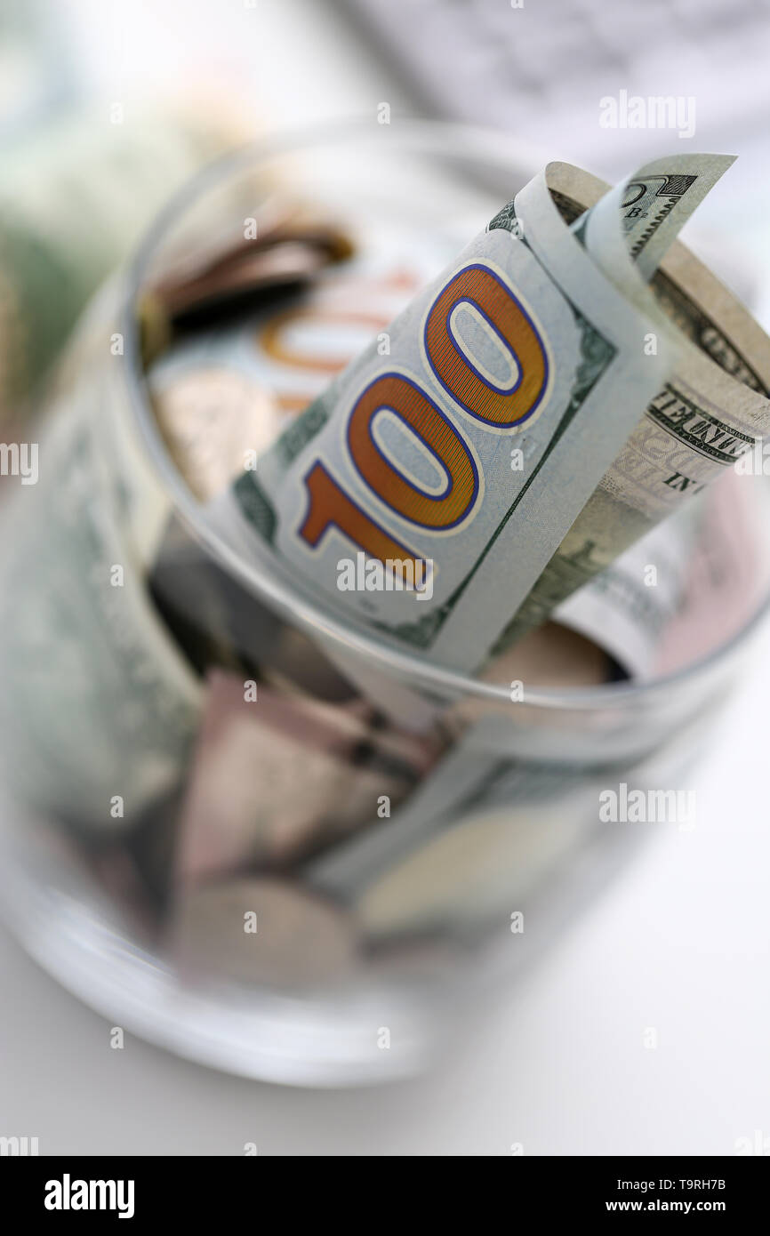 Big jar full of US notes and coins standing on empty worktable Stock ...