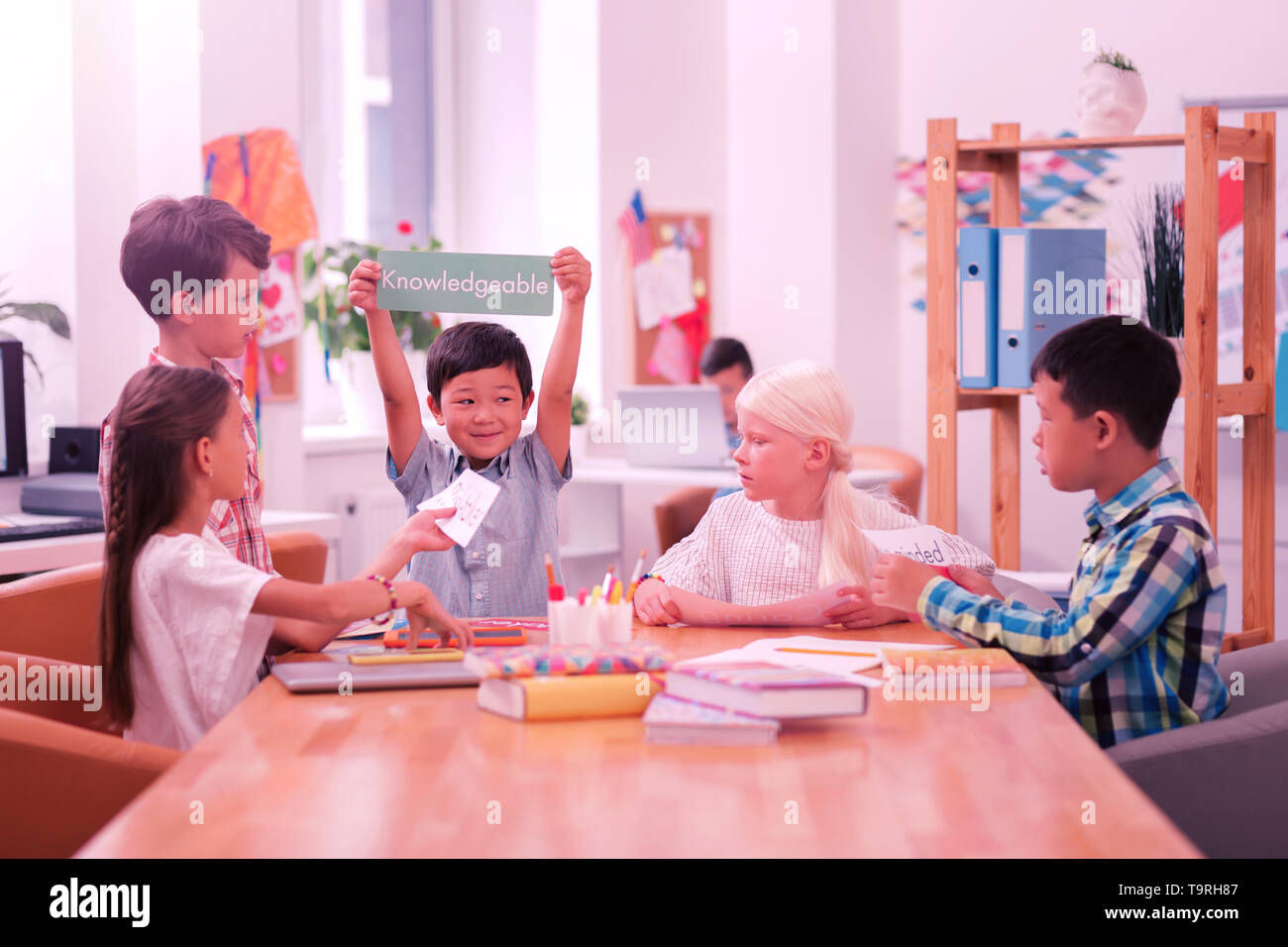Pupils holding sheets of paper with English words Stock Photo - Alamy
