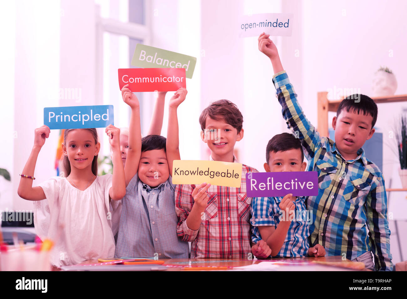 Children holding up sheets of paper with English words Stock Photo - Alamy