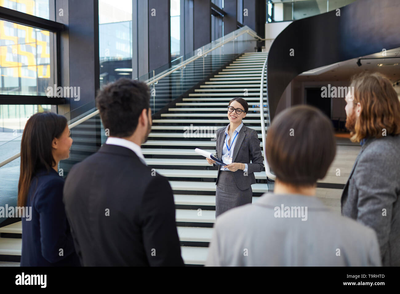 Business forum guide giving tour to participants Stock Photo - Alamy