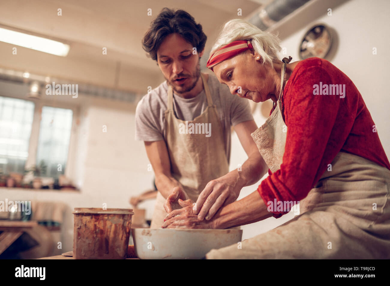 Nice pleasant man helping an aged woman Stock Photo - Alamy
