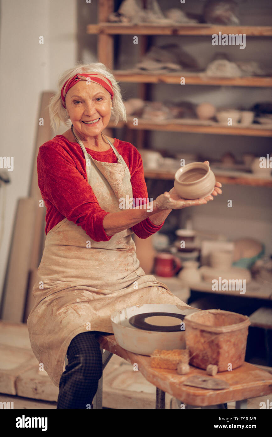 Delighted happy woman showing her clay pot Stock Photo - Alamy